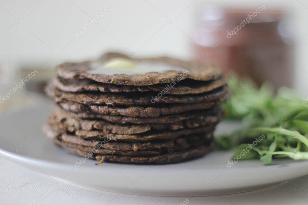 Pan plano con mijo de dedo y hojas de alholva servidas con cuajada de ...