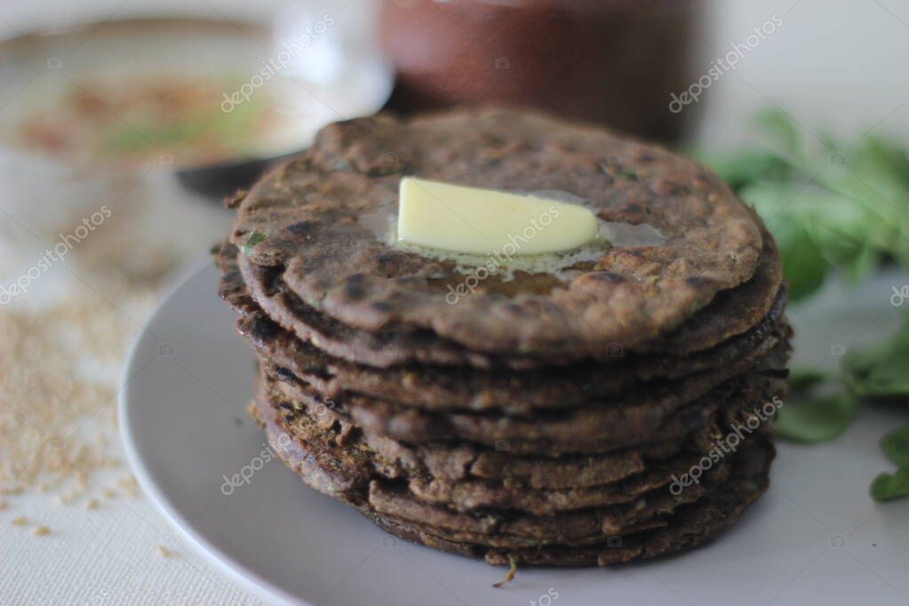 Pan plano con mijo de dedo y hojas de alholva servidas con cuajada de ...