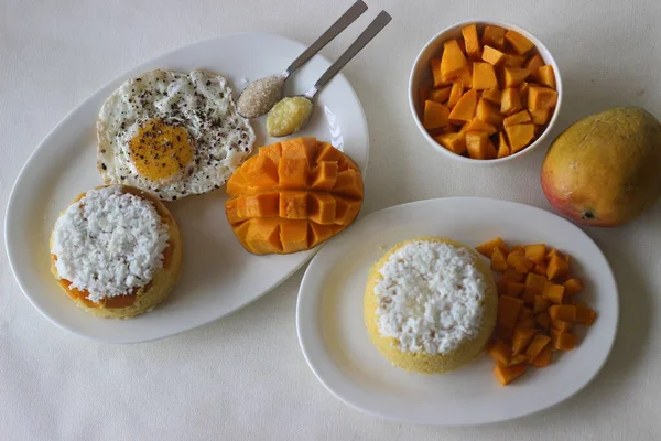 Arroz molido al vapor, en capas con virutas de coco y mango. Localmente ...