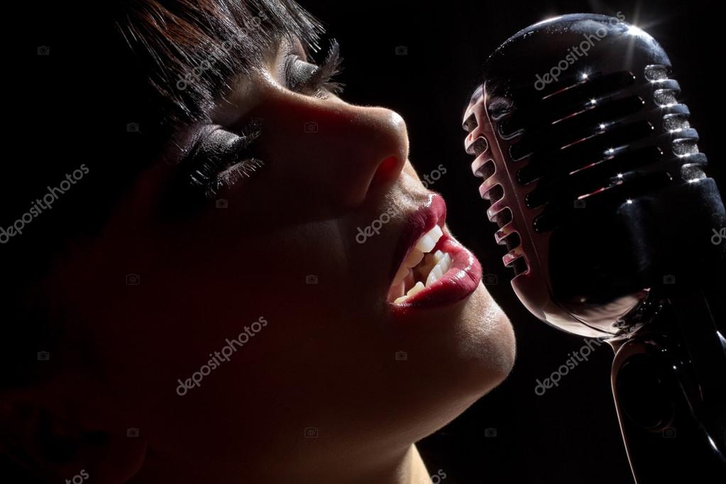 Singer woman with microphone Stock Photo by ©korolOK 73348601