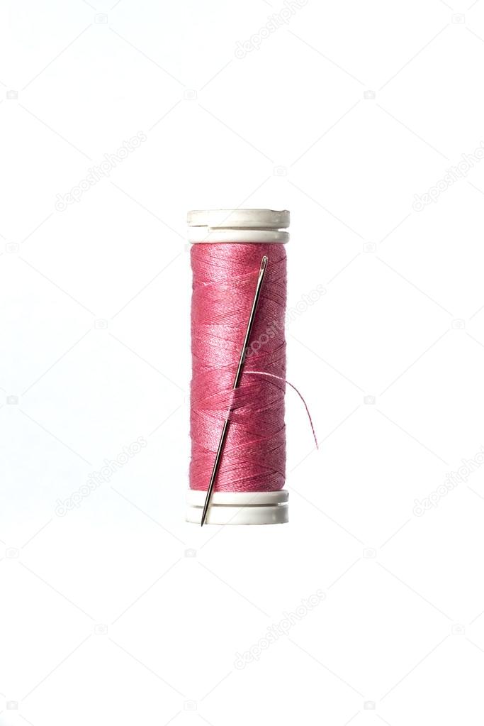 Embedded needle in a spool of pink sewing — Stock Photo © Martinotero ...