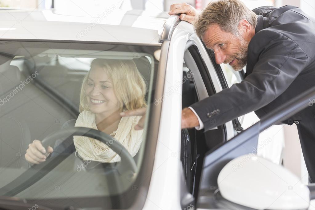 Car dealer showing vehicle binnacle to clients Stock Photo by ...