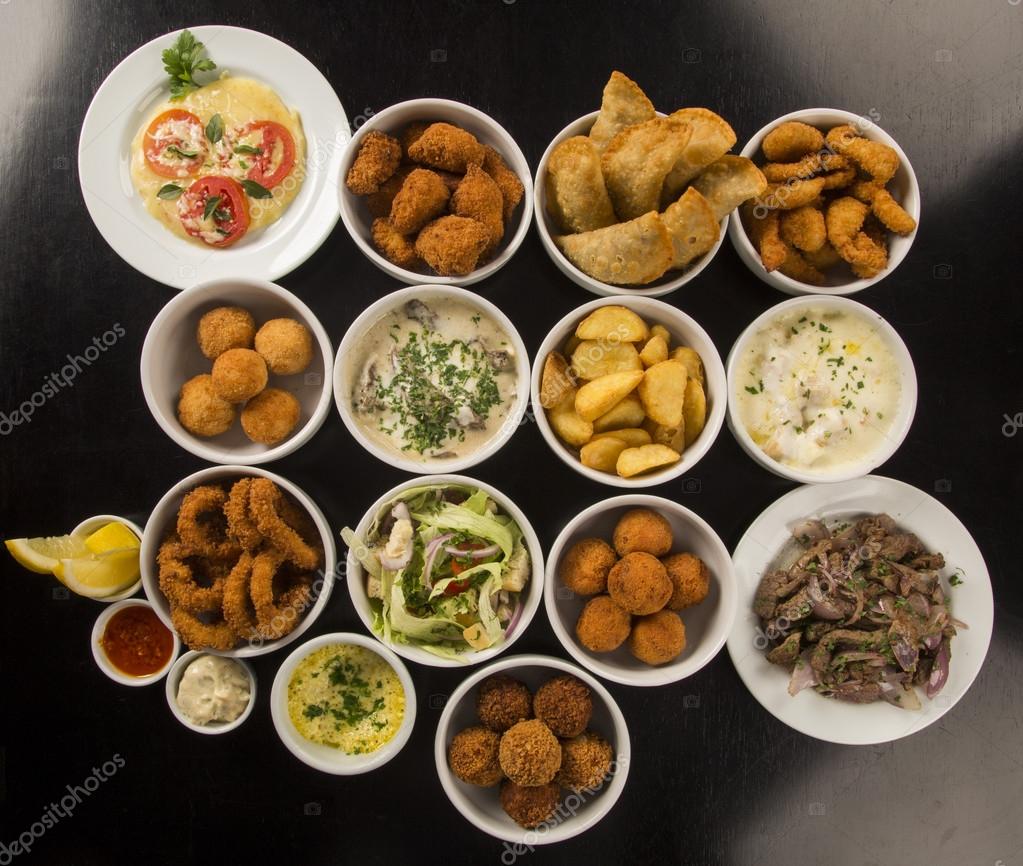 Mixed brazilian snacks, including pastries, fried chicken, salad ...