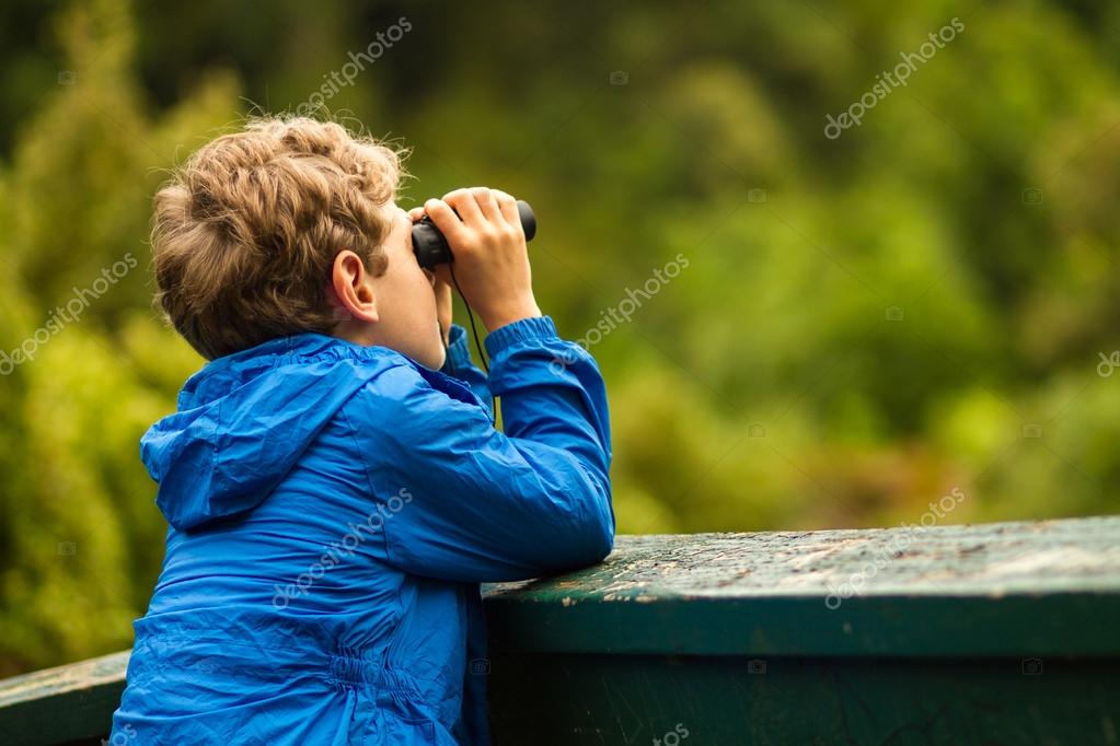 Young boy bird watching in a forest Stock Photo by ©taonga 109939060