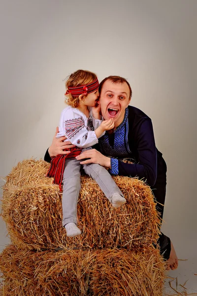 Dad and daughter in ethnic clothes in the manger - Stock Image - Everypixel