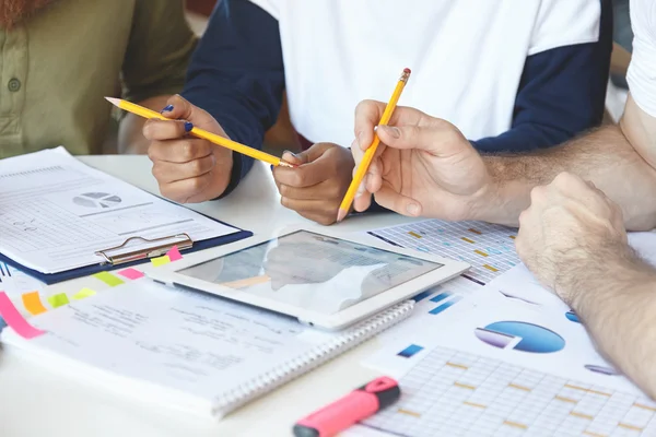 Group of office workers holding pencils, working together on financial ...