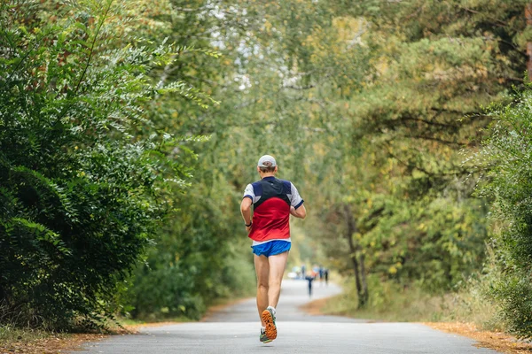 Young male runner marathon running in autumn forest. - Stock Image ...