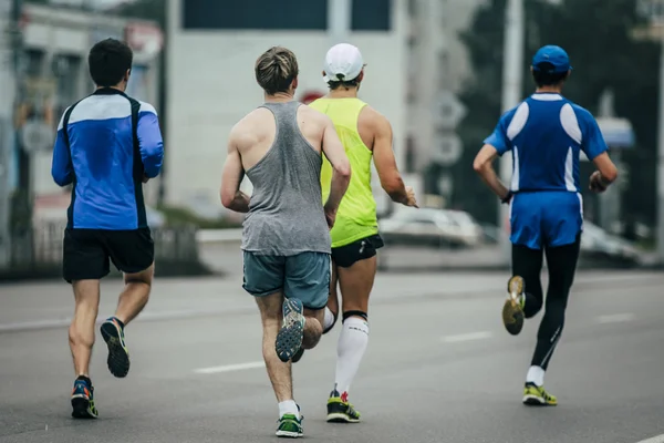 group of young runners running through streets of city – Stock ...