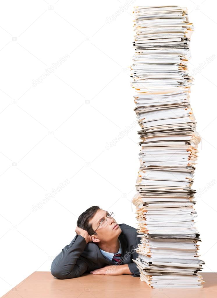 Young man looking on stack of papers — Stock Photo © billiondigital ...