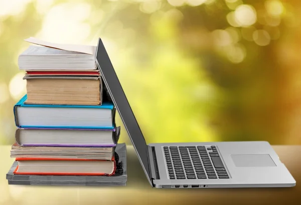 Stack of books with laptop Stock Photo by ©billiondigital 118714404
