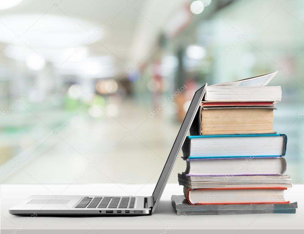 Stack of books with laptop Stock Photo by ©billiondigital 118714404