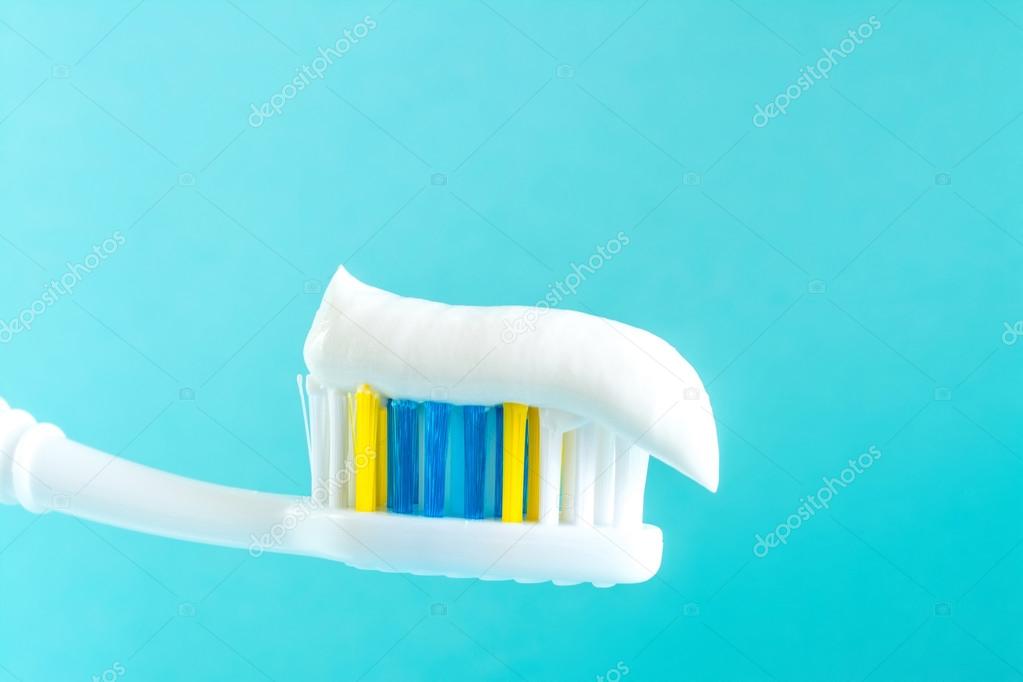 Toothpaste on a toothbrush close-up on a blue background — Stock Photo ...