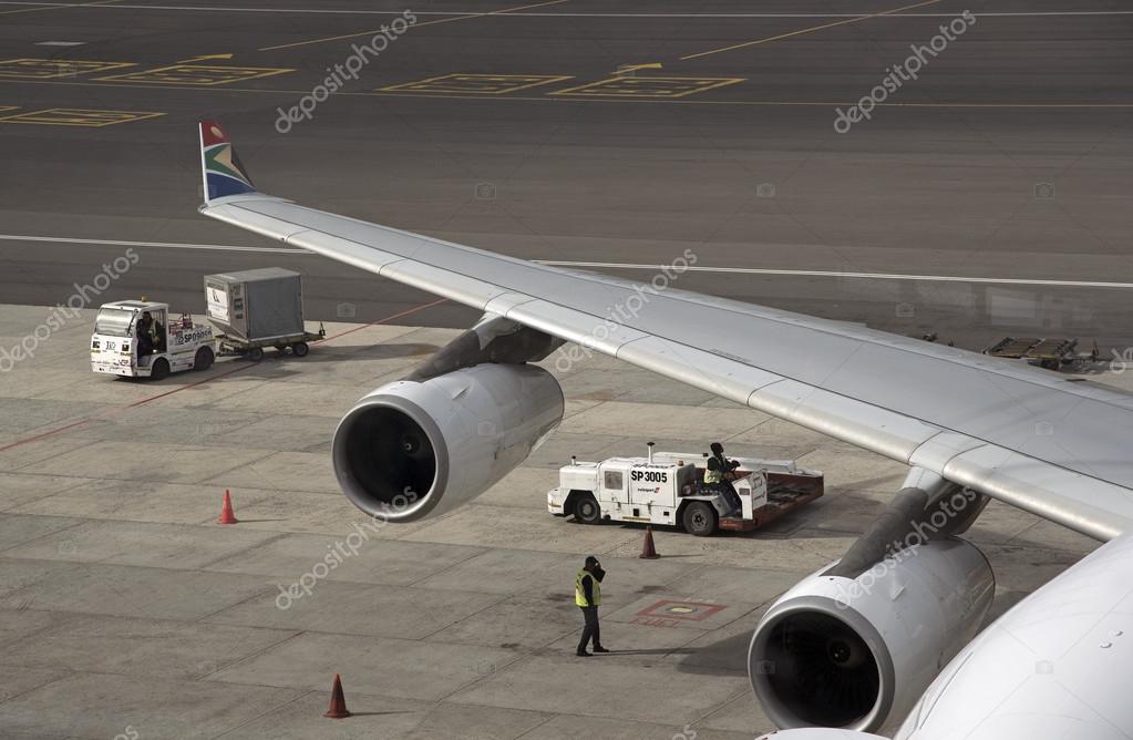 Trabajadores del aeropuerto prestan servicio en un avión en el ...