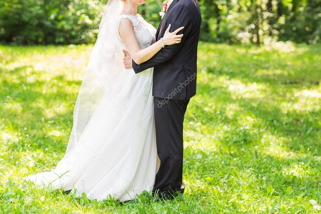 Wedding couple hugging, bride holding a bouquet of flowers, the groom ...