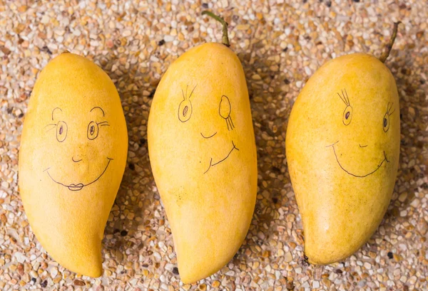 Drawn smiley face on a mango fruit. Fruits, diet, healthy food concept ...