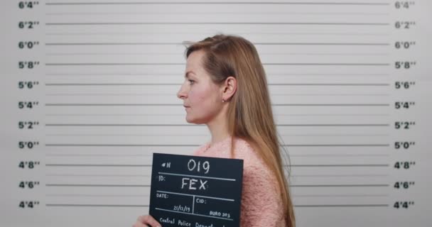 Side profile mugshot of arrested young woman with long hair turning ...