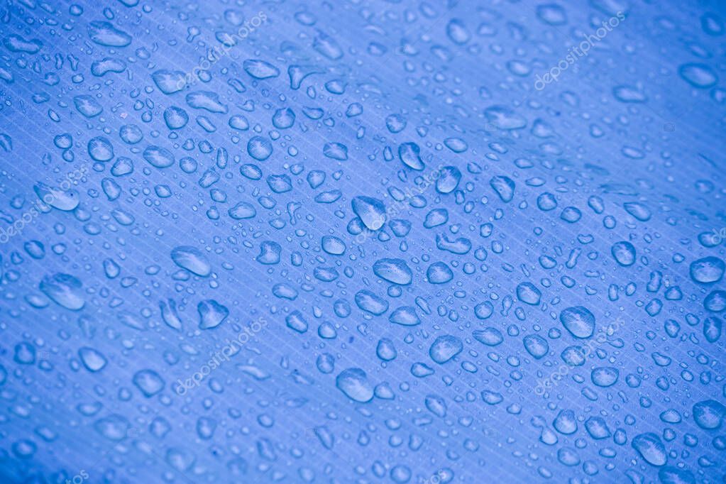 Tejido repelente al agua en grandes gotas de lluvia. Tejido rip-stop ...