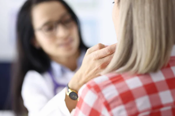 Médico femenino palpando pacientes ganglios linfáticos submandibulares ...