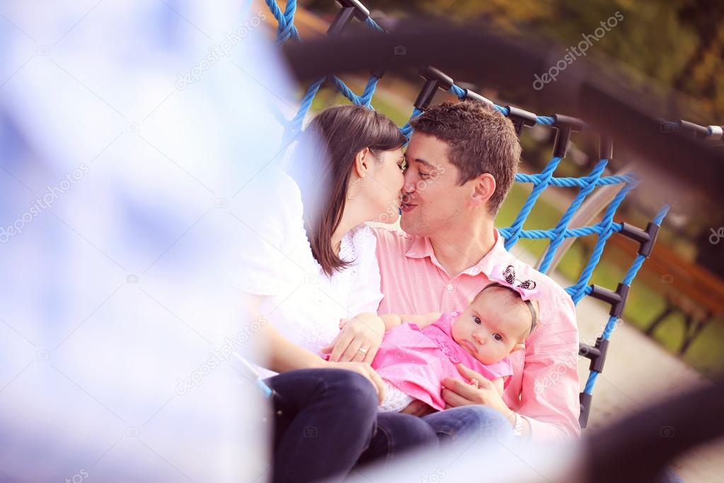 Affectionate parents with their baby girl in the park — Stock Photo ...
