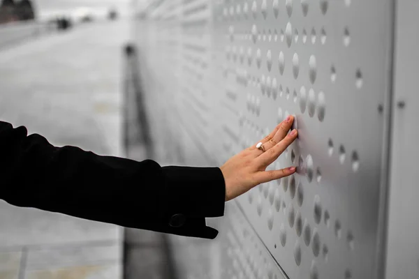 Hand reading Braille (tactile) writing system on the outter walls of ...