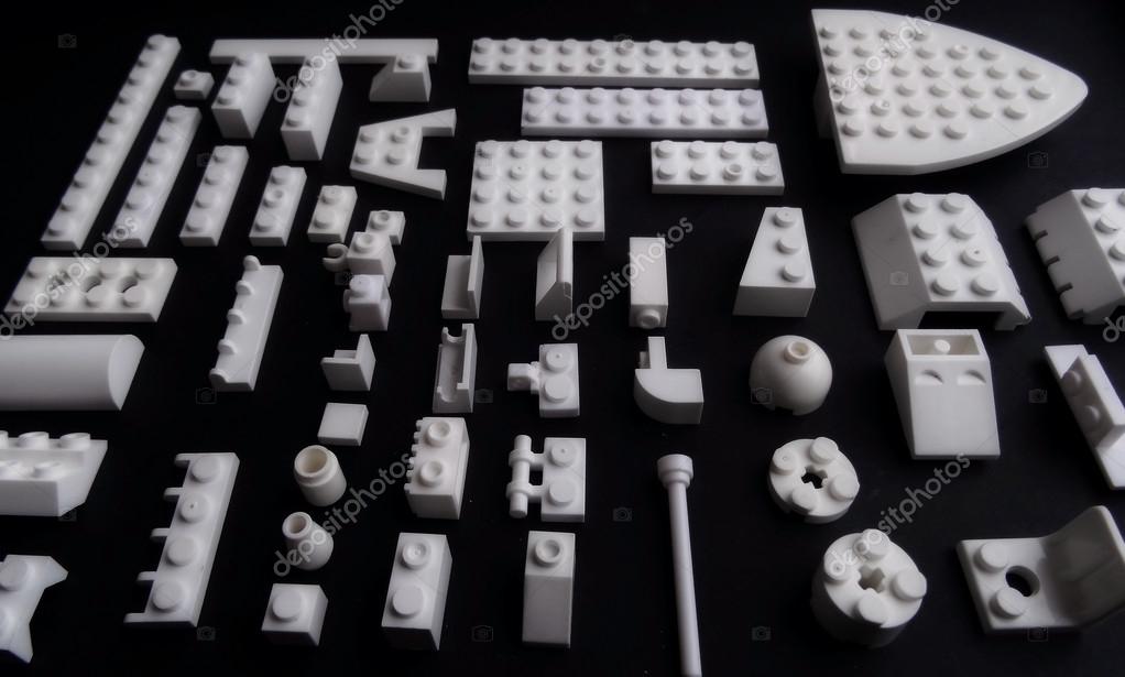 White plastic blocks of toy constructor on black surface studio ...