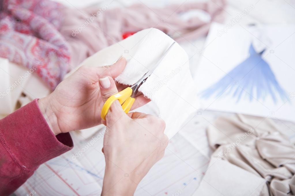 Taylor cutting fabric using a scissor.Cutting fabric with a taylor ...
