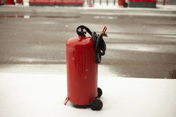 A fire extinguisher at a gas station. A large cylinder with a fire ...