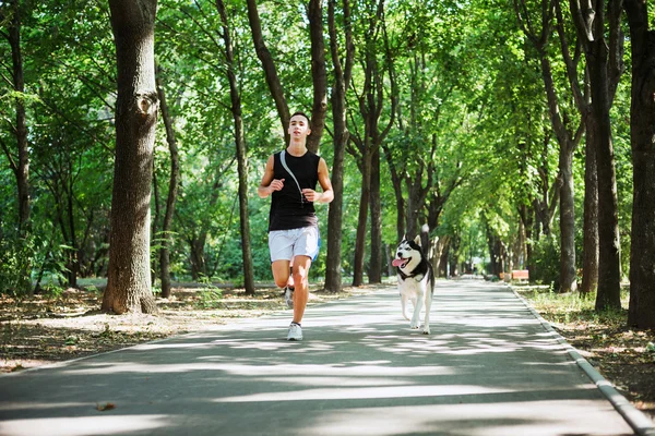 work out with dog. Young caucasian male running with siberian hu ...