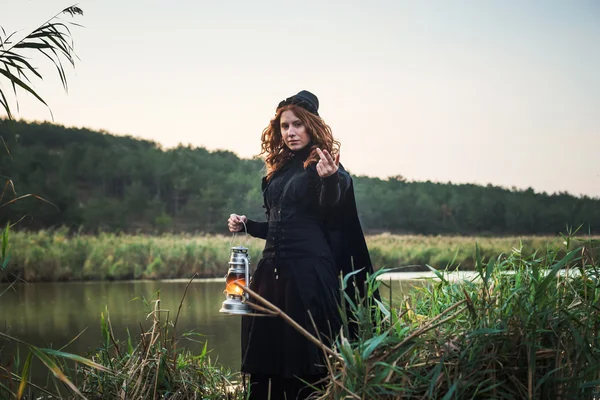 Witch with light on a swamp. Witch practicing magic on a swamp ...