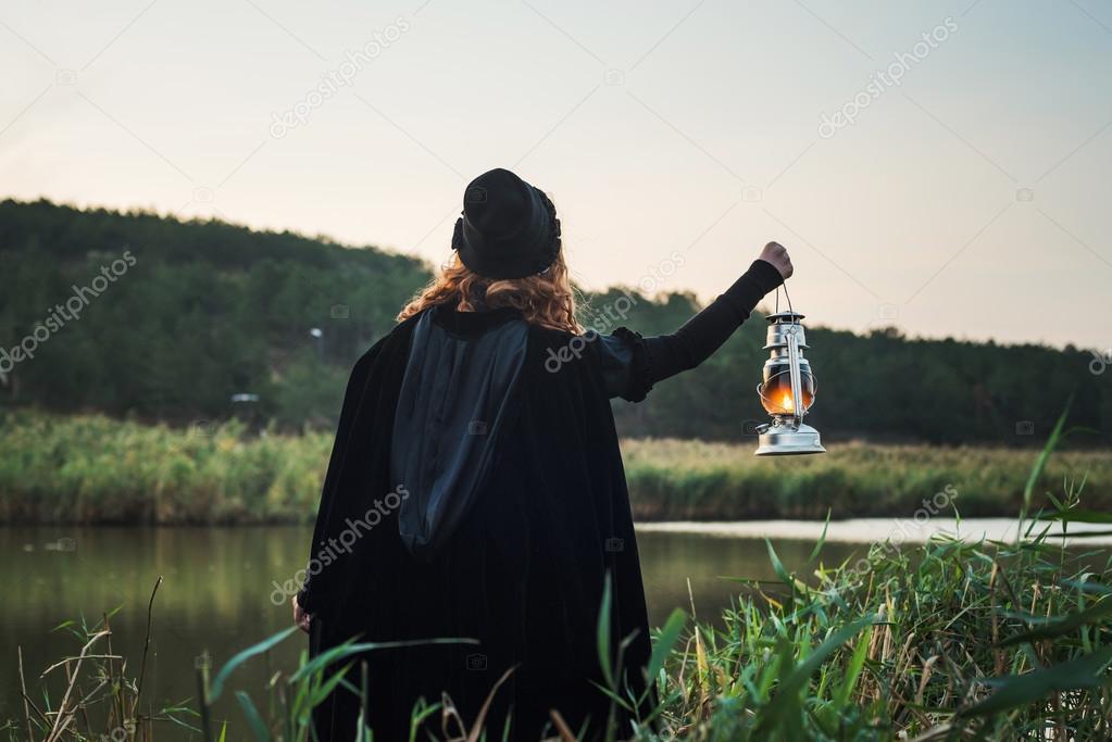 Witch with light on a swamp. Witch practicing magic on a swamp ...