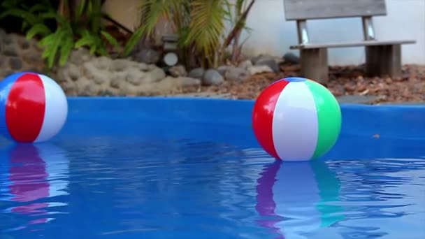 Beach ball in pool. Colorful inflatable ball floating in swimming pool ...