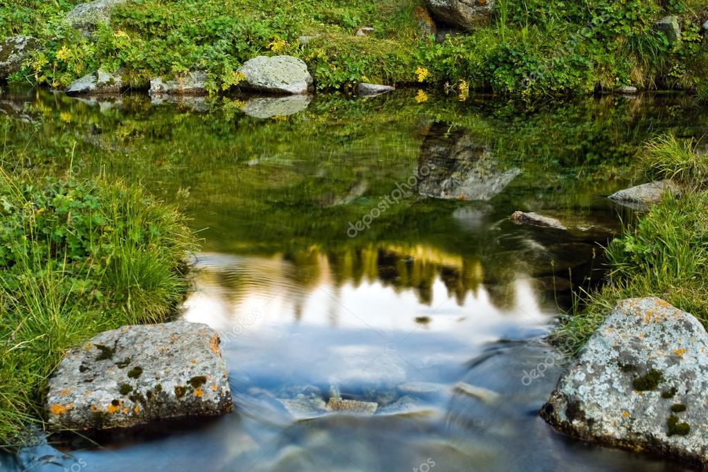Long exposure image of mountain lake falling and flowing trough Stock ...