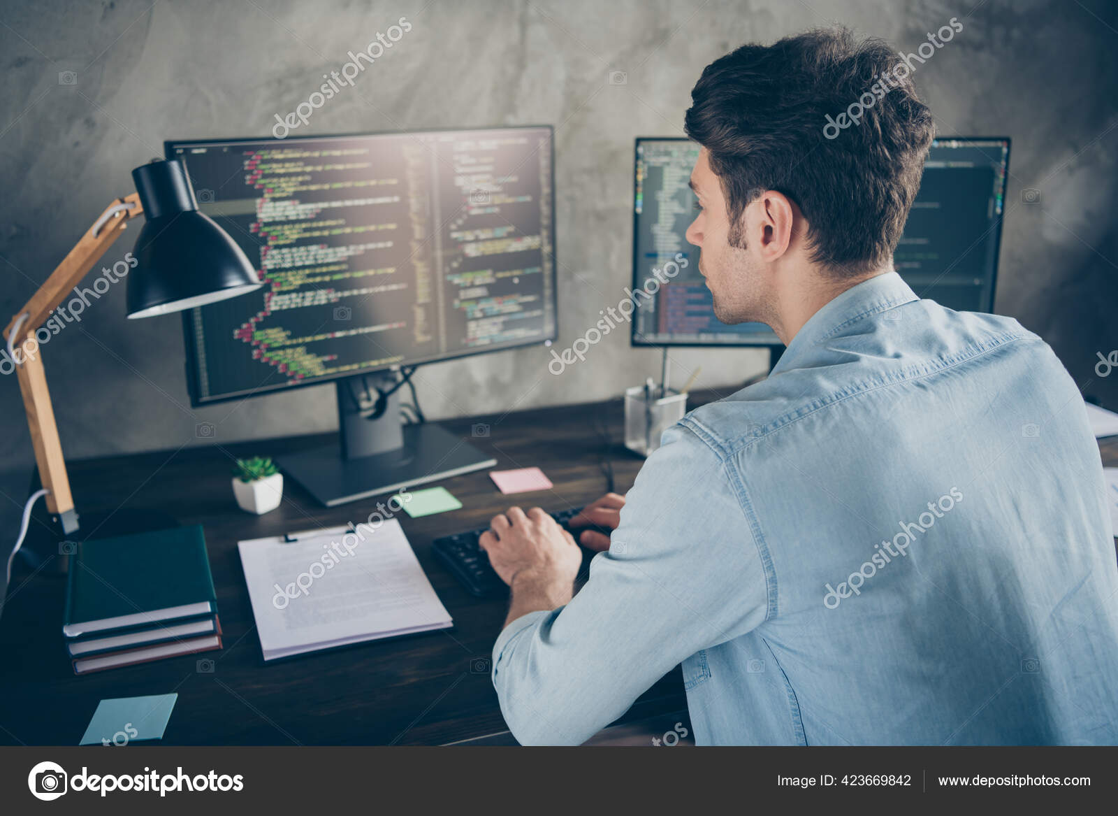 Rear back behind view portrait of his he nice attractive focused geek guy typing css analyzing ...