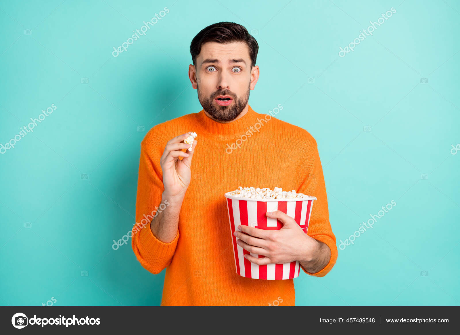 Photo of young guy afraid scared frightened eat popcorn watch horror ...