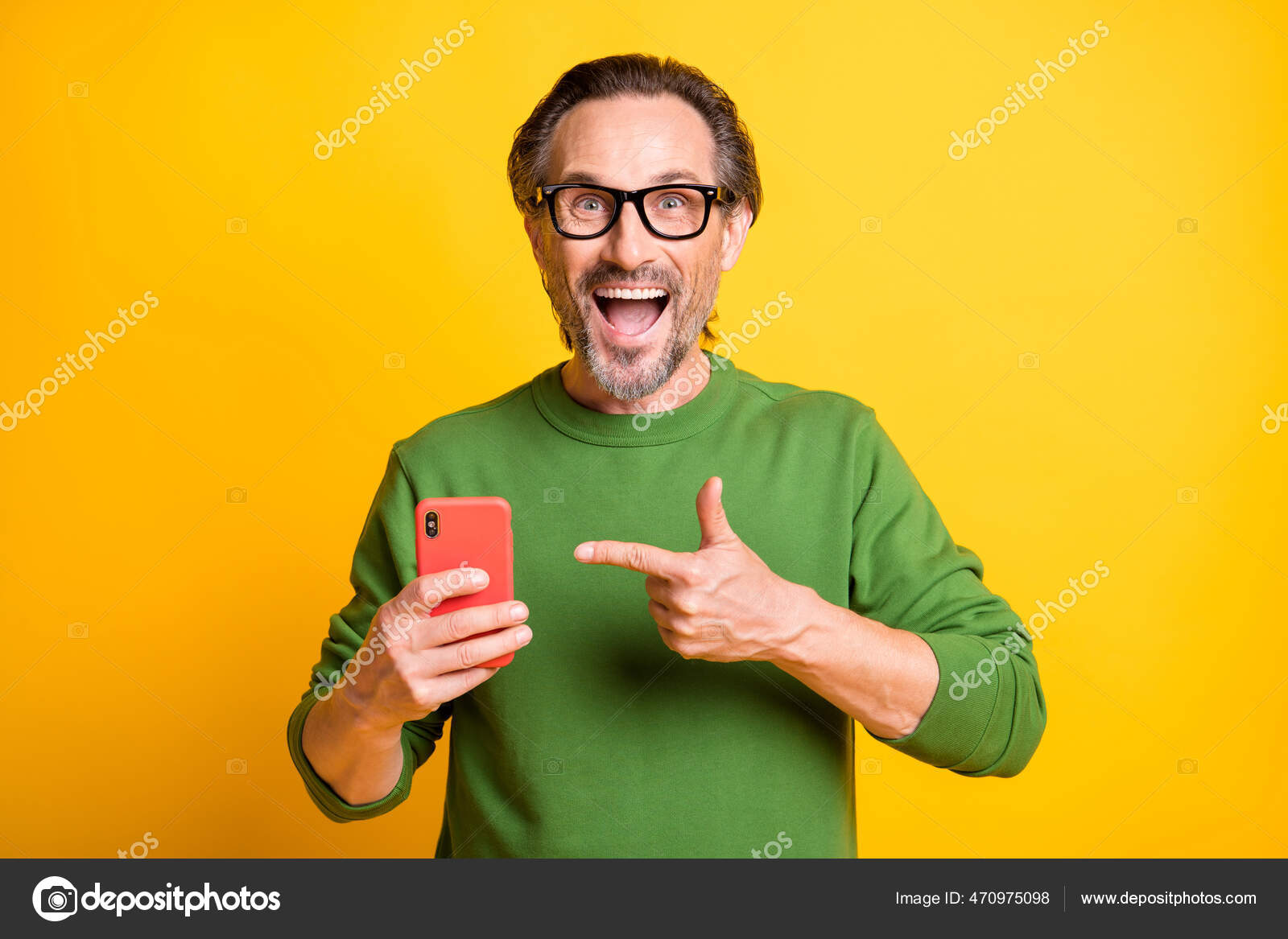 Photo of amazed guy hold telephone direct forefinger open mouth wear eyeglasses green sweater ...