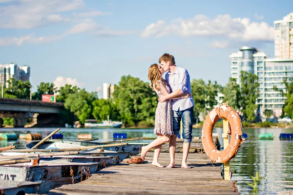 Couple In Love Sitting On A Wooden Pier Near The Boat Man And Woman