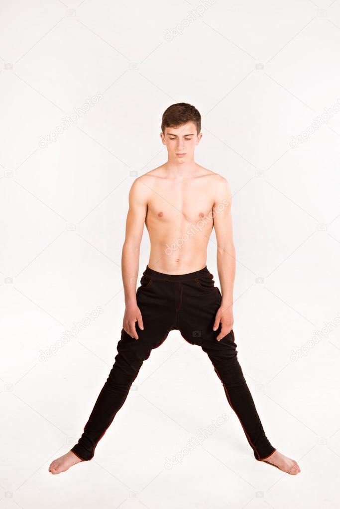 Slender man doing gymnastic exercises. Gymnast standing on white ...