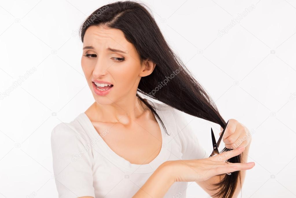 Sad shoked young woman cutting her long hair Stock Photo by ©deagreez1 ...