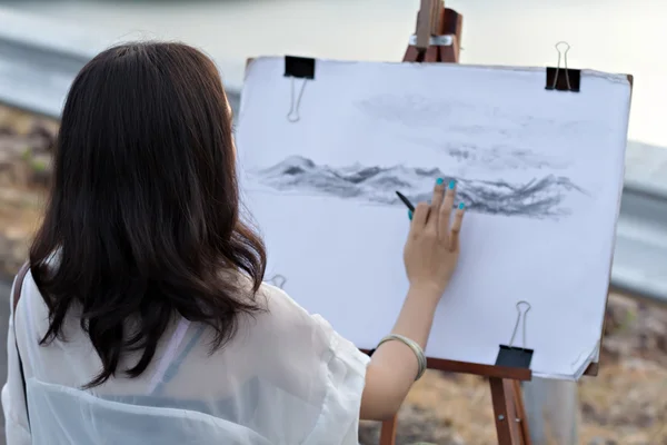 Young artist sketching a landscape focus on head - Stock Image - Everypixel