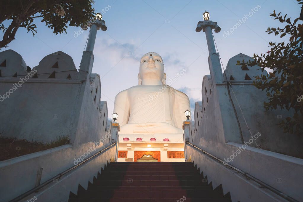 Pasos que conducen a la estatua gigante de Buda blanco iluminada por la ...
