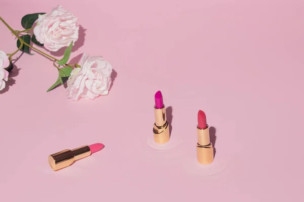 Old style layout with golden lipsticks and flowers on pastel pink ...