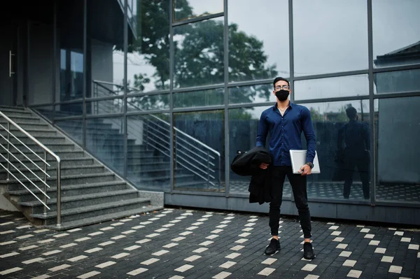 Middle eastern entrepreneur wear black face mask and eyeglasses hold ...