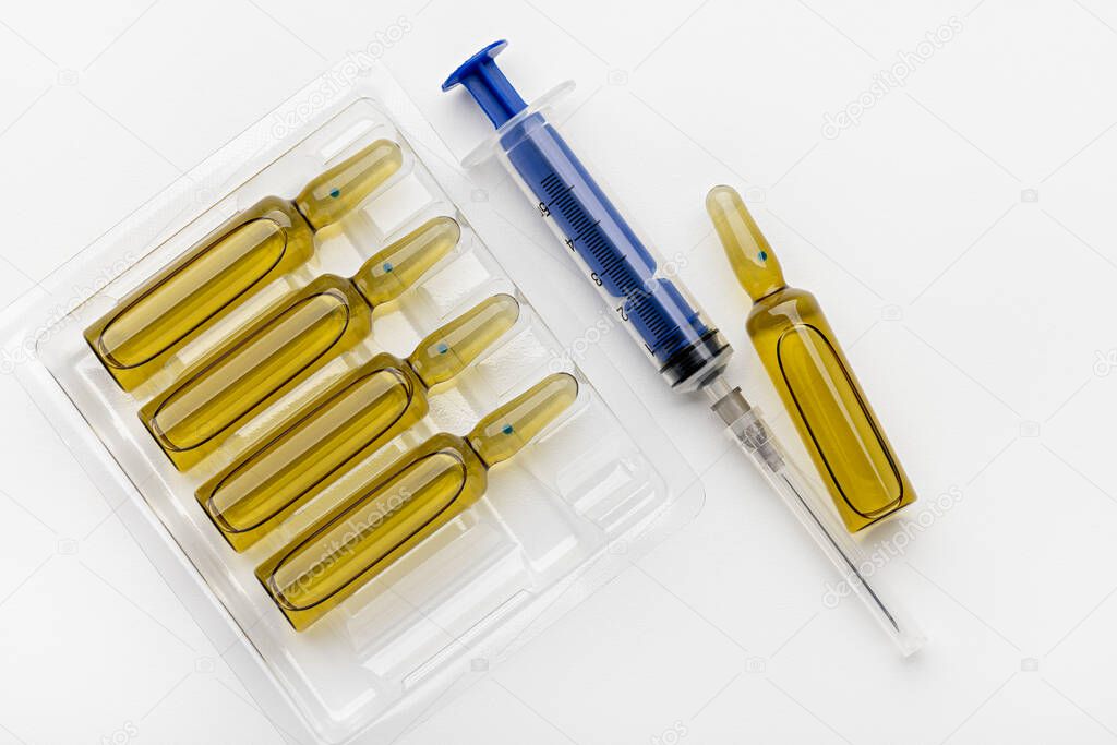 Dos ampollas verticales con medicación y una jeringa desechable sobre ...