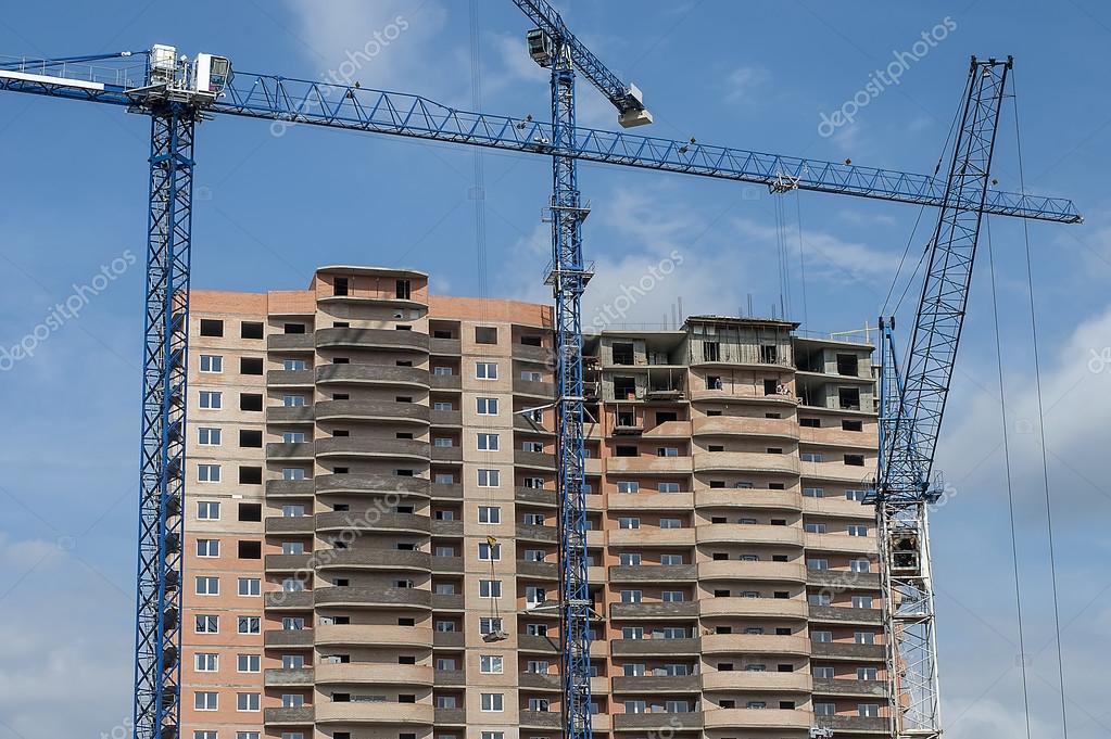 A new high-rise building and three construction cranes — Stock Photo ...