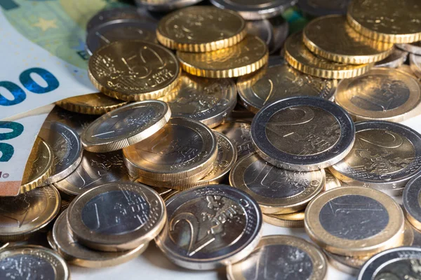 Many Euro coins and euro bills. Banknotes on the left and coins on the ...