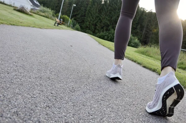 Closeup of a woman in running shoes, walking or taking a run to be fit ...