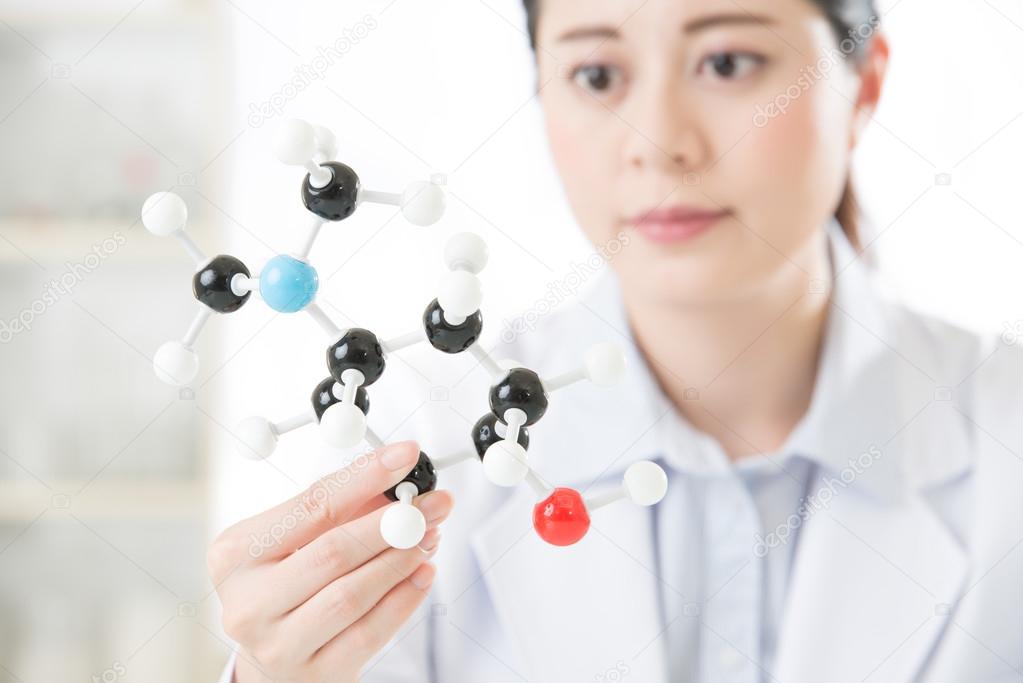 Asian female scientist looking at molecular model doing the scie ... Asian female scientist looking at molecular model doing the scie ...