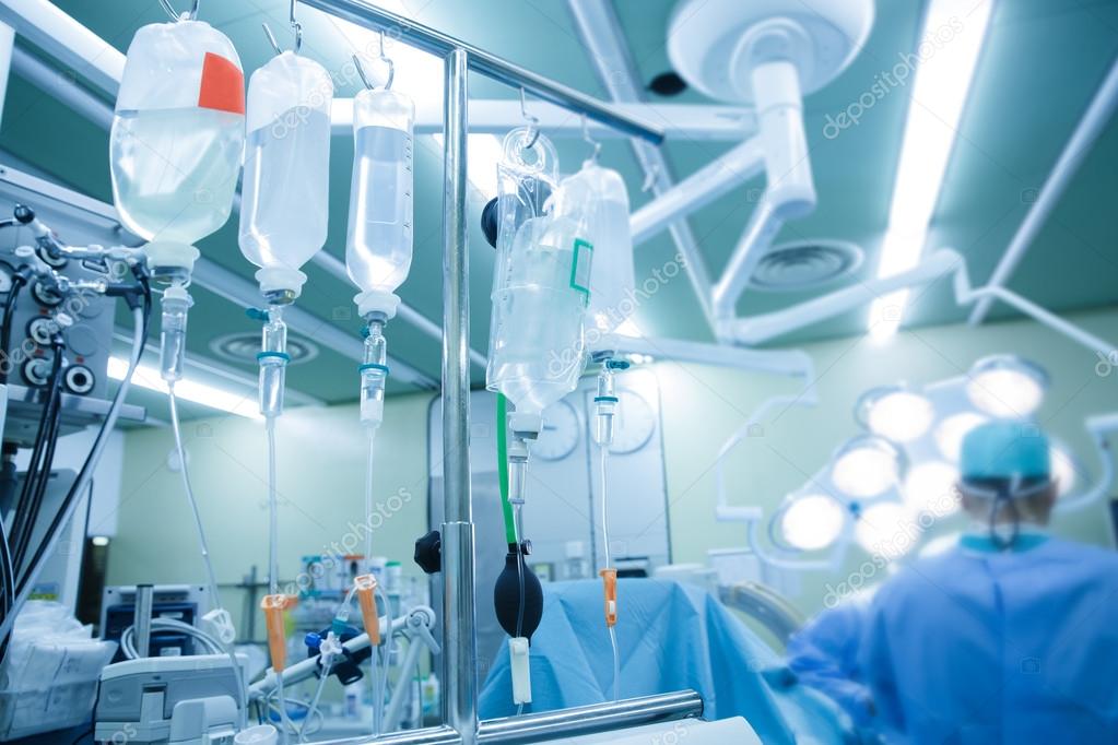 IV bags and bottles hanging on poles during a real surgery Stock Photo ...