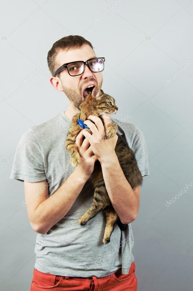 Young man eating a cat — Stock Photo © Patramansky #76338987