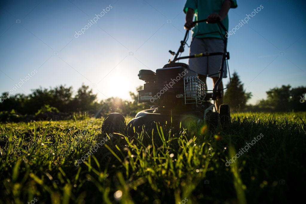 Young man mowing the grass — Stock Photo © StockWithMe #76072169